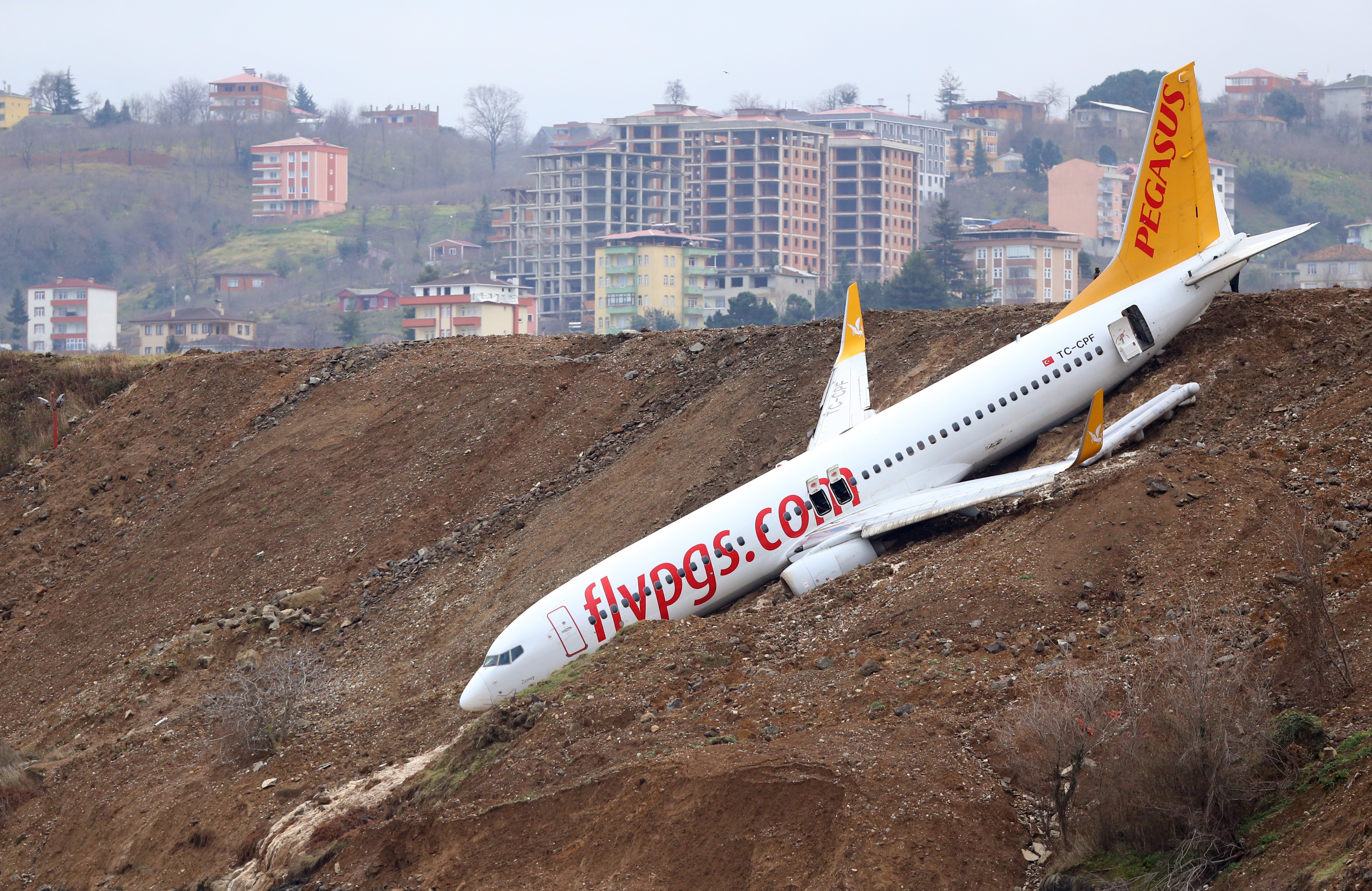 Airplane perched on cliff after skidding off runway